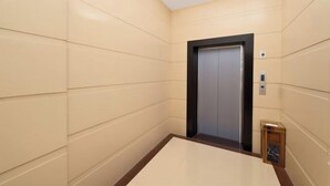 Um elevador estreito com paredes bege e design moderno.