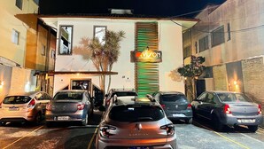Uma área de estacionamento com vários carros estacionados em frente a um edifício com uma placa que diz 'OVION paisada'.