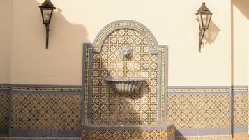Um edifício com entrada em azulejos, um reservatório de água e uma escadaria.