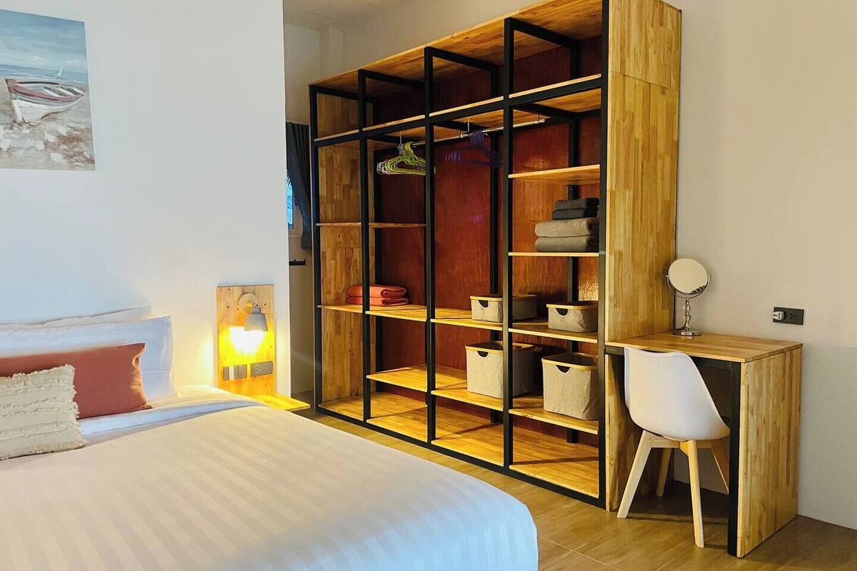 Quarto com cama, escrivaninha, cadeira, guarda-roupa e abajur.