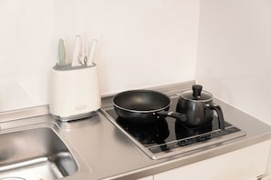 Um frigorífico, um micro-ondas, uma placa de cozinha 