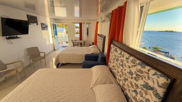 Quarto quádruplo superior, 2 camas de casal, vista para o oceano | Cortinas blackout, Wi-Fi de cortesia, roupa de cama