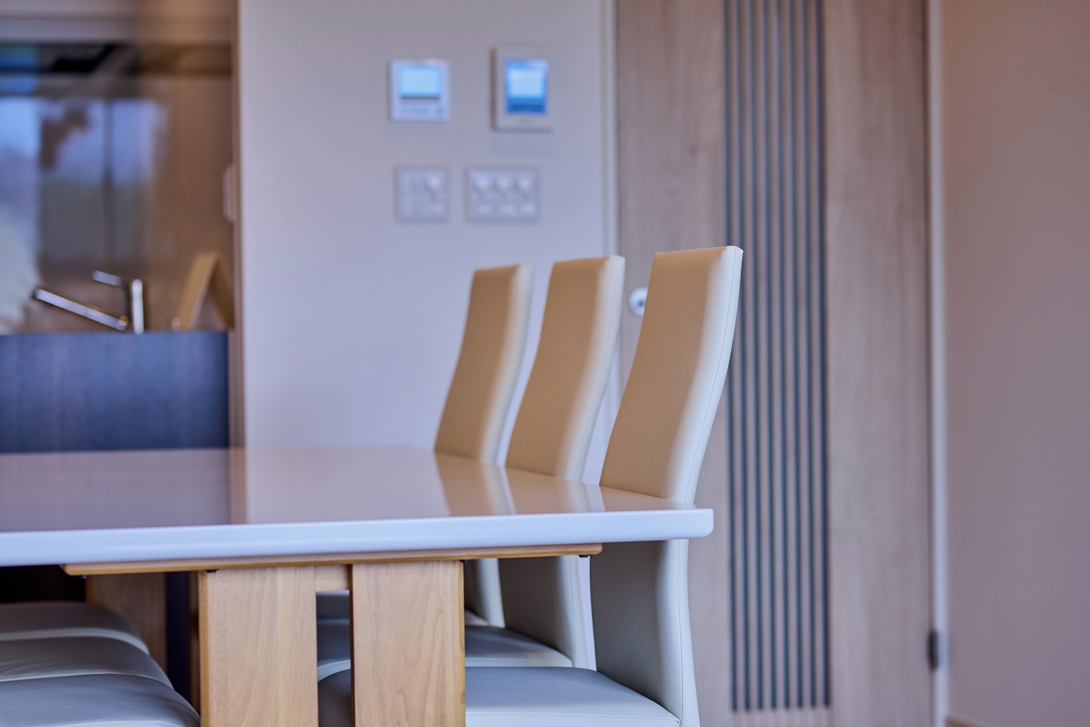 Uma sala de conferências moderna com uma mesa branca e cadeiras bege.