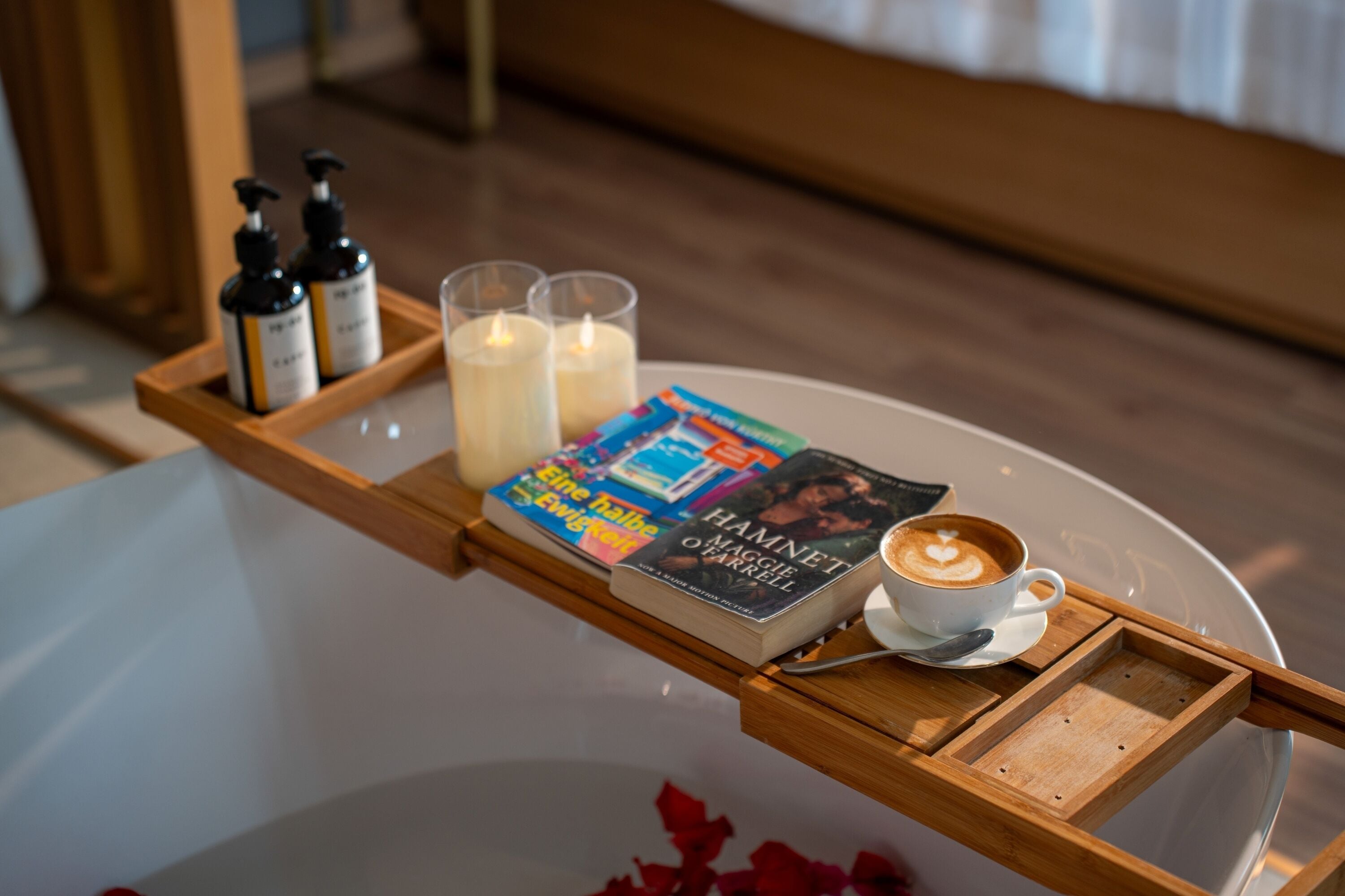 Uma mesa com um livro, velas, uma xícara de café e artigos de higiene pessoal.