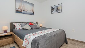 Quarto com cama, mesas de cabeceira, tapete e obras de arte nas paredes.