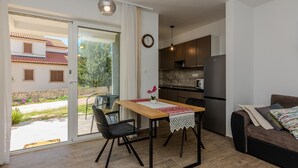 Um apartamento moderno com área de jantar, cozinha compacta e sofá.