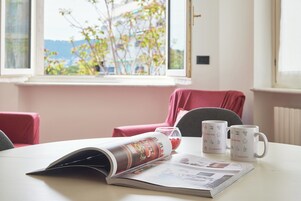 Revista sobre uma mesa com duas canecas e um copo de bebida vermelha.