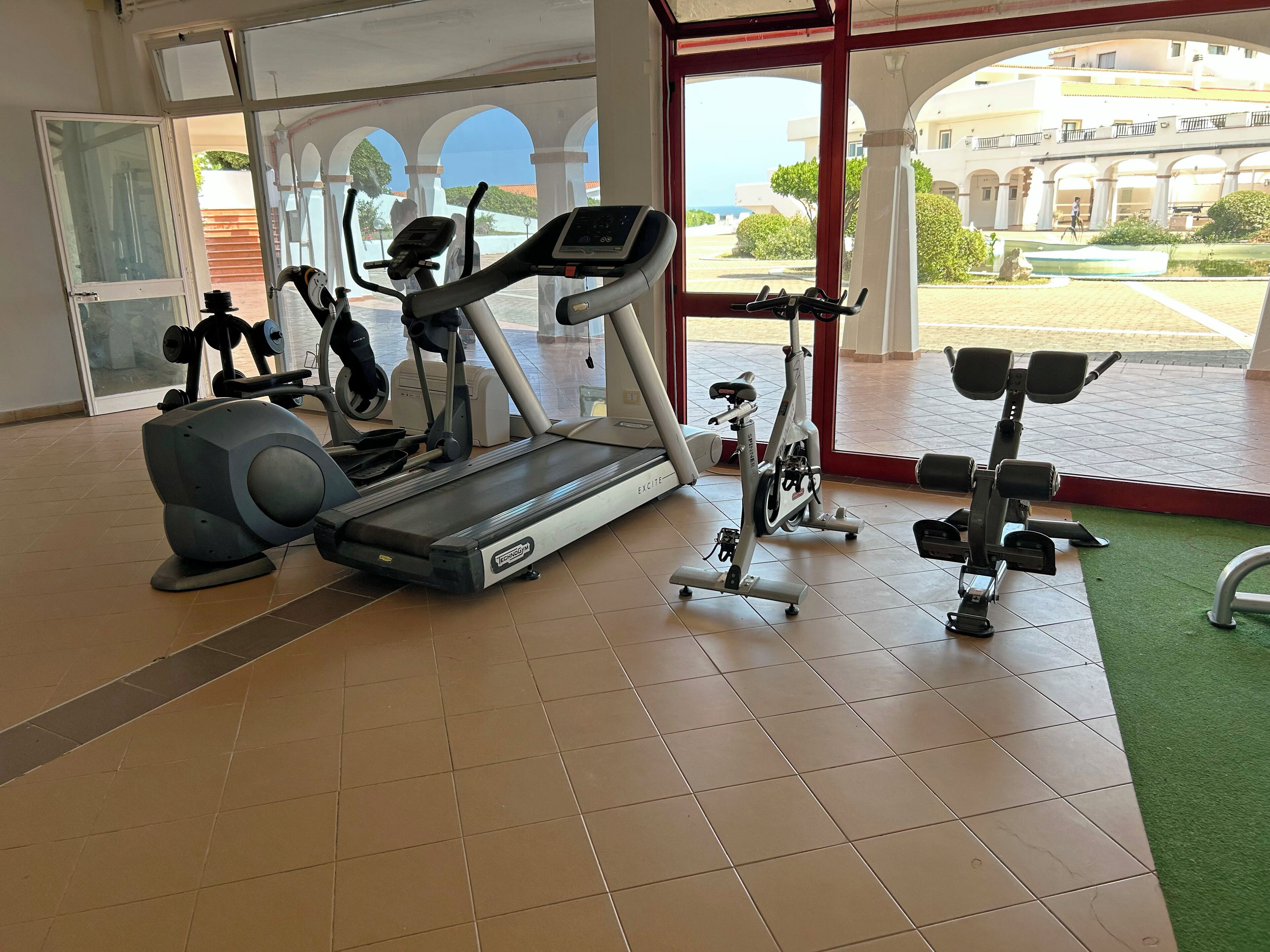 Uma academia com esteiras, bicicletas ergométricas e aparelhos de musculação.