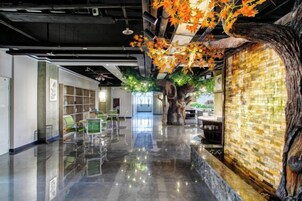 Interior moderno com piso lustroso, áreas de estar e uma estrutura decorativa em forma de árvore.