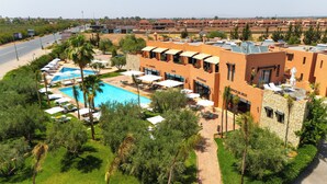 Hotel com piscina, área de estar externa e restaurante.