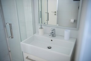 Apartamento luxo, vista para o jardim | Banheiro | Chuveiro, secador de cabelo, toalhas de banho, sabonete