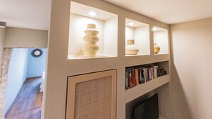 Um interior moderno com uma estante, lareira e vasos decorativos.