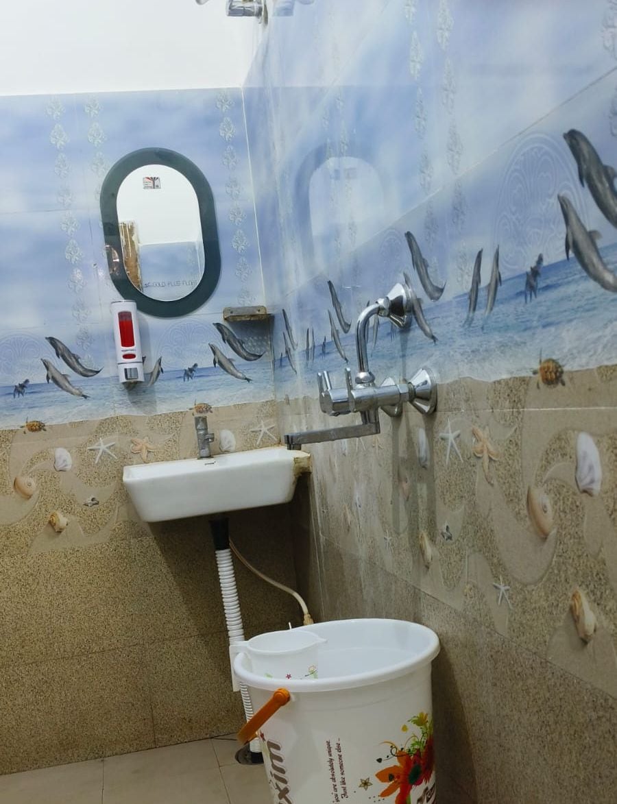Casa de banho com mural temático do mar, uma pia e um secador de mãos.