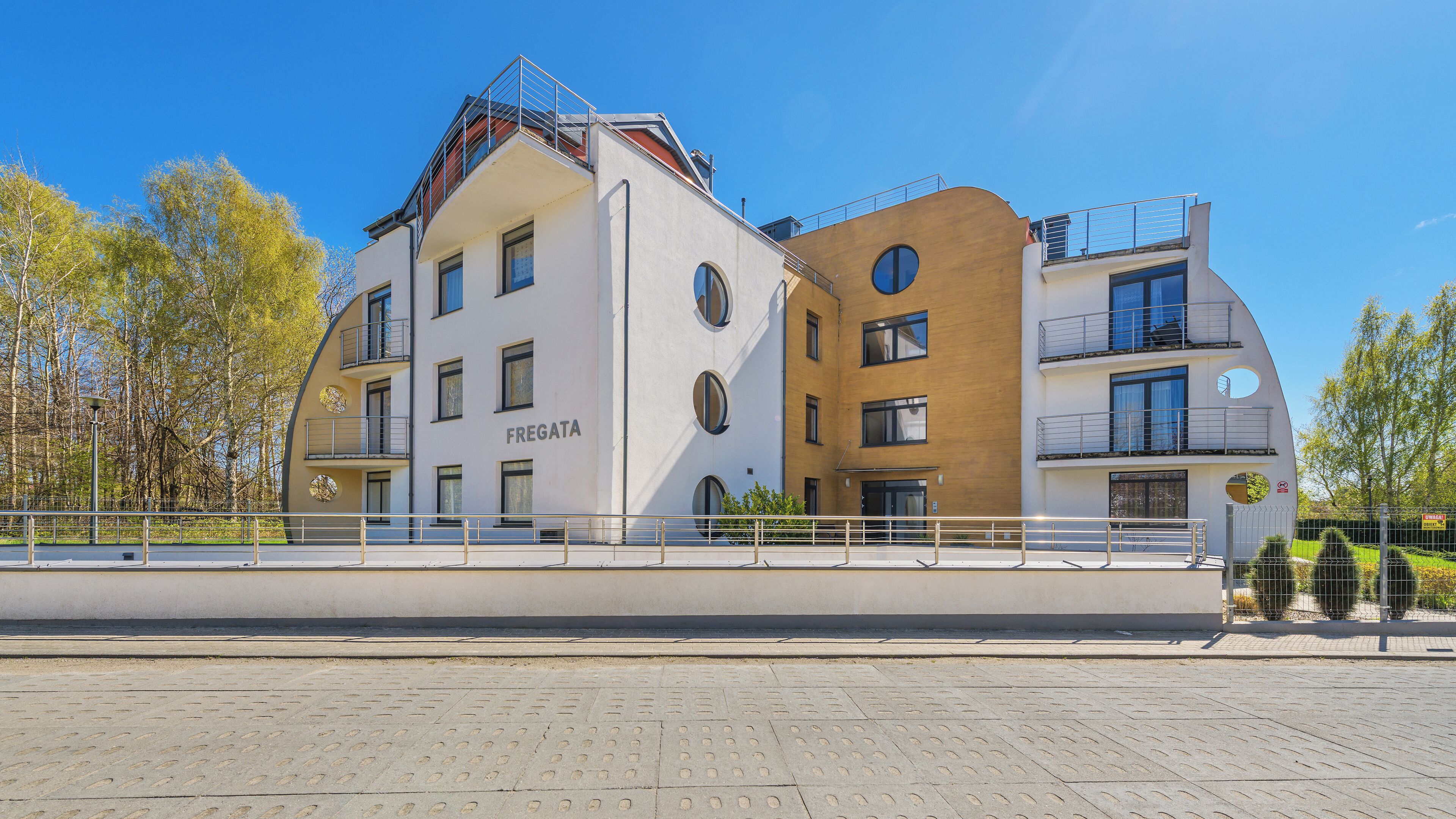 Um edifício moderno com vários andares, varandas e uma placa com o nome 'FREGATA'.