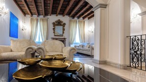 Uma sala de estar espaçosa com pé direito alto, móveis elegantes e um espelho grande.