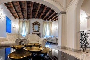 Uma sala de estar espaçosa com pé direito alto, móveis elegantes e um espelho grande.