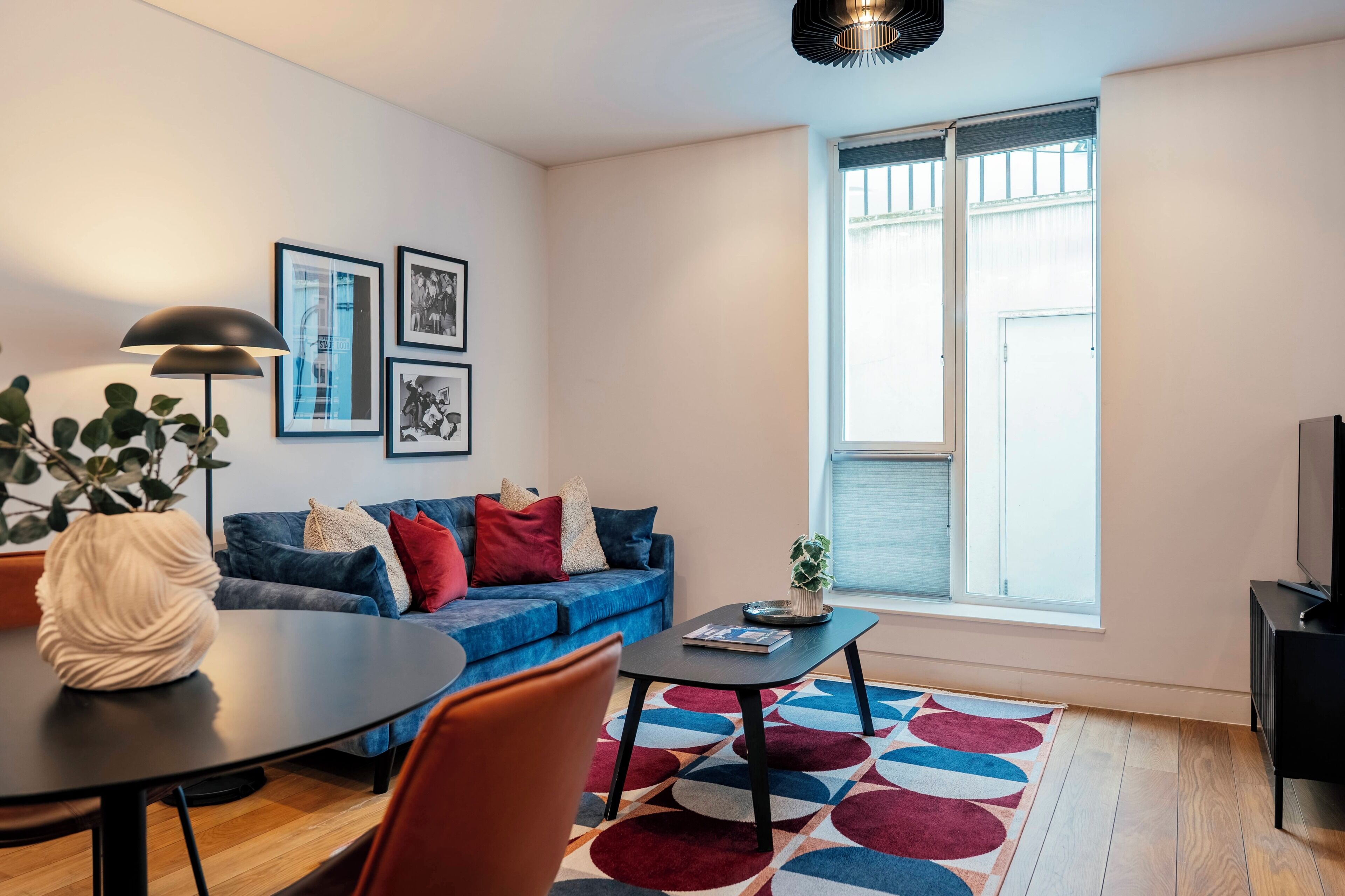 Uma sala de estar moderna com sofá, mesa de centro e área de jantar.