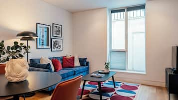 Uma sala de estar moderna com sofá, mesa de centro e área de jantar.