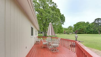 Um deck de madeira com móveis de exterior e guarda-corpo vermelho.