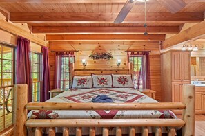 Quarto de cabana de madeira com cama, cortinas e janela.