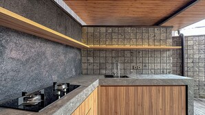 Uma cozinha moderna com fogão embutido, pia e armários de madeira.