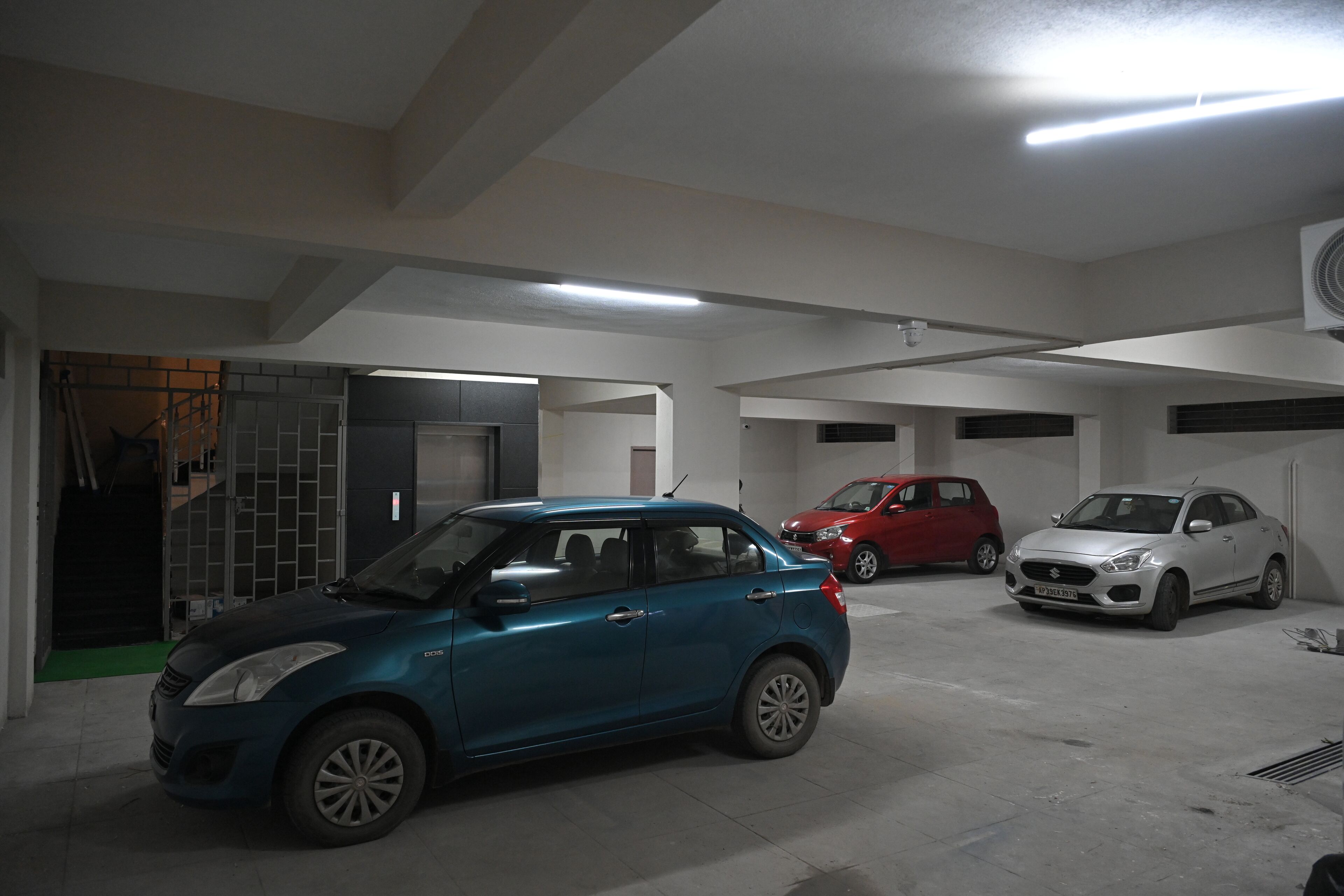 Uma garagem de estacionamento com três carros.