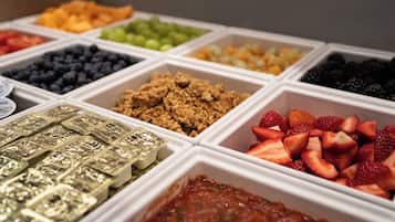 Exposição de alimentos com diversas frutas e barras de granola.