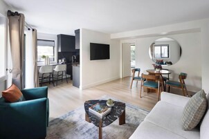 Uma sala de estar moderna com sofá, mesa de centro e canto de jantar com cadeiras e mesa.