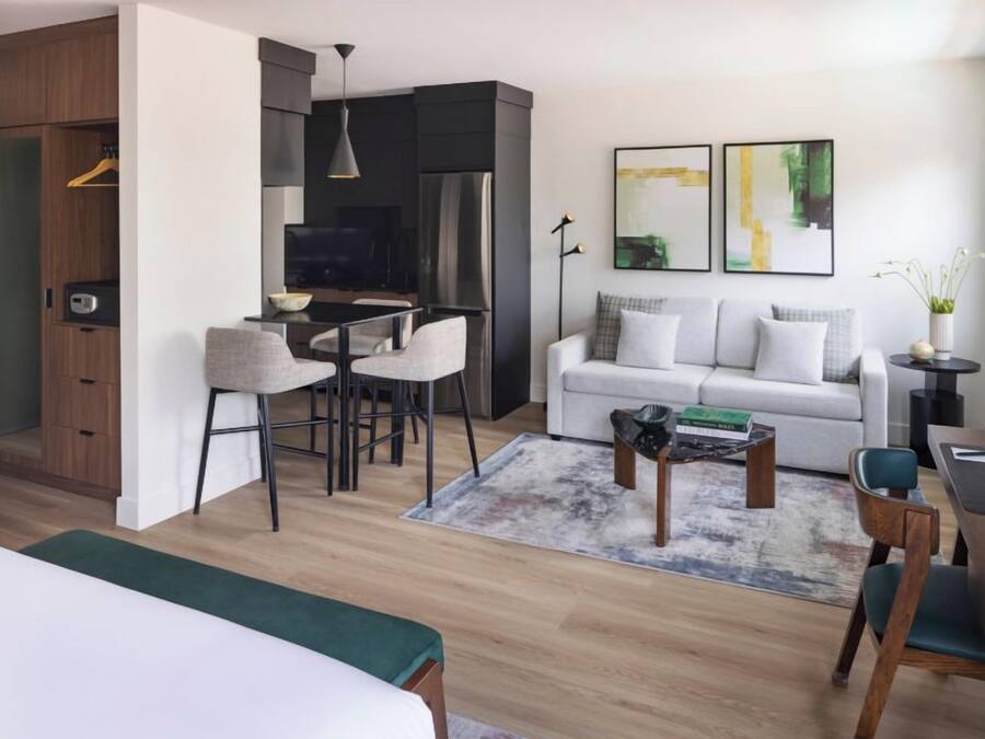 Uma sala de estar moderna com um sofá, cadeiras, uma mesa de centro e um espaço para refeições.