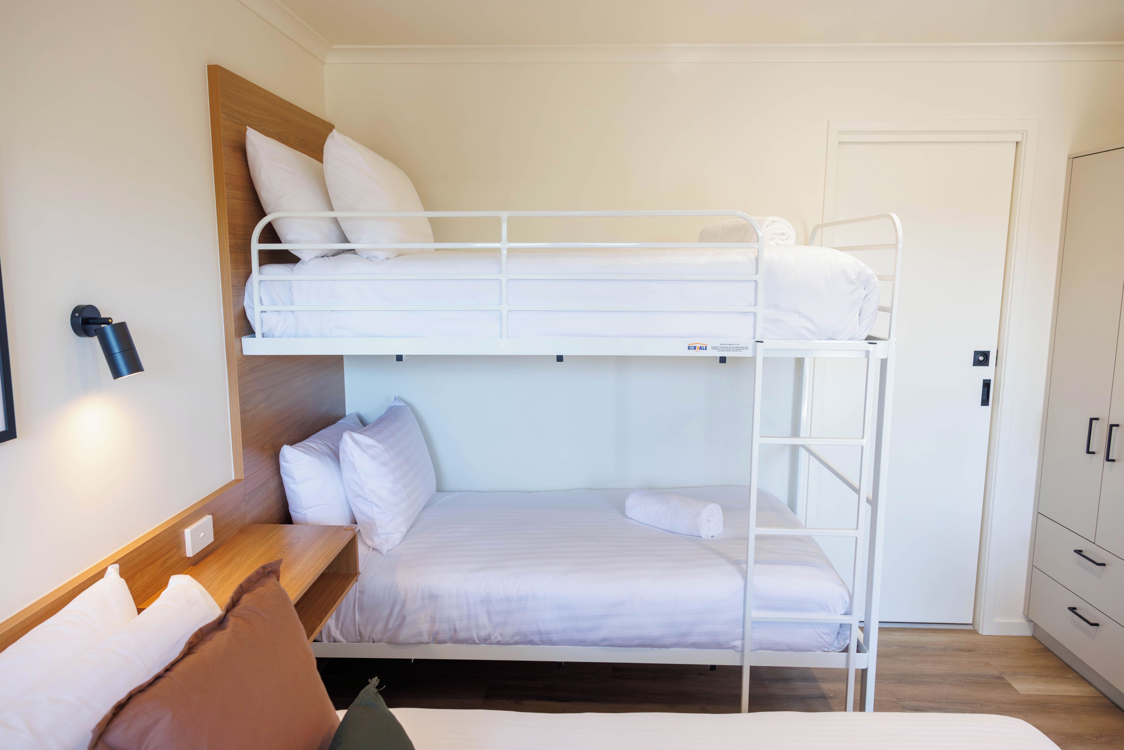 Quarto com beliche, escrivaninha e guarda-roupa.