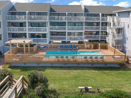 Um hotel com vários andares, área de piscina, mobiliário de exterior e um relvado bem cuidado.