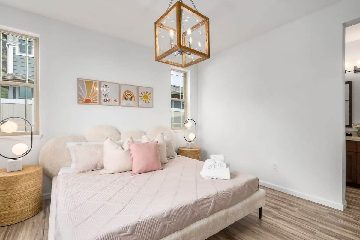Quarto com cama grande, abajures e quadros nas paredes.