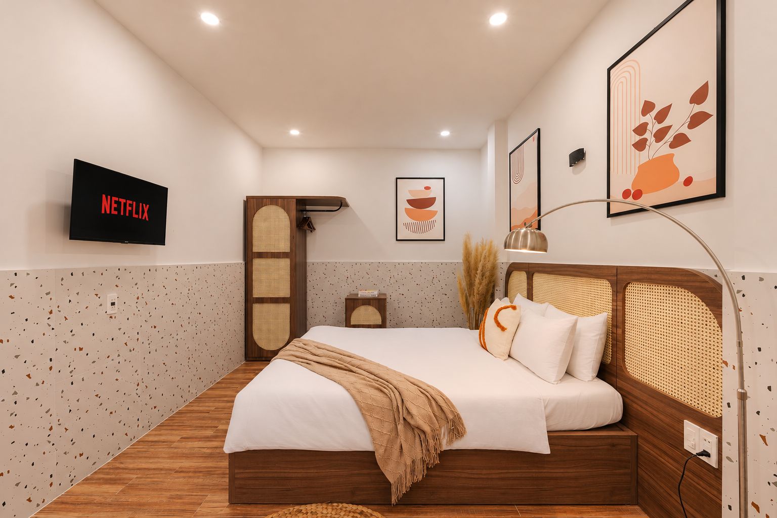 Quarto moderno com uma cama, televisão e obras de arte nas paredes.