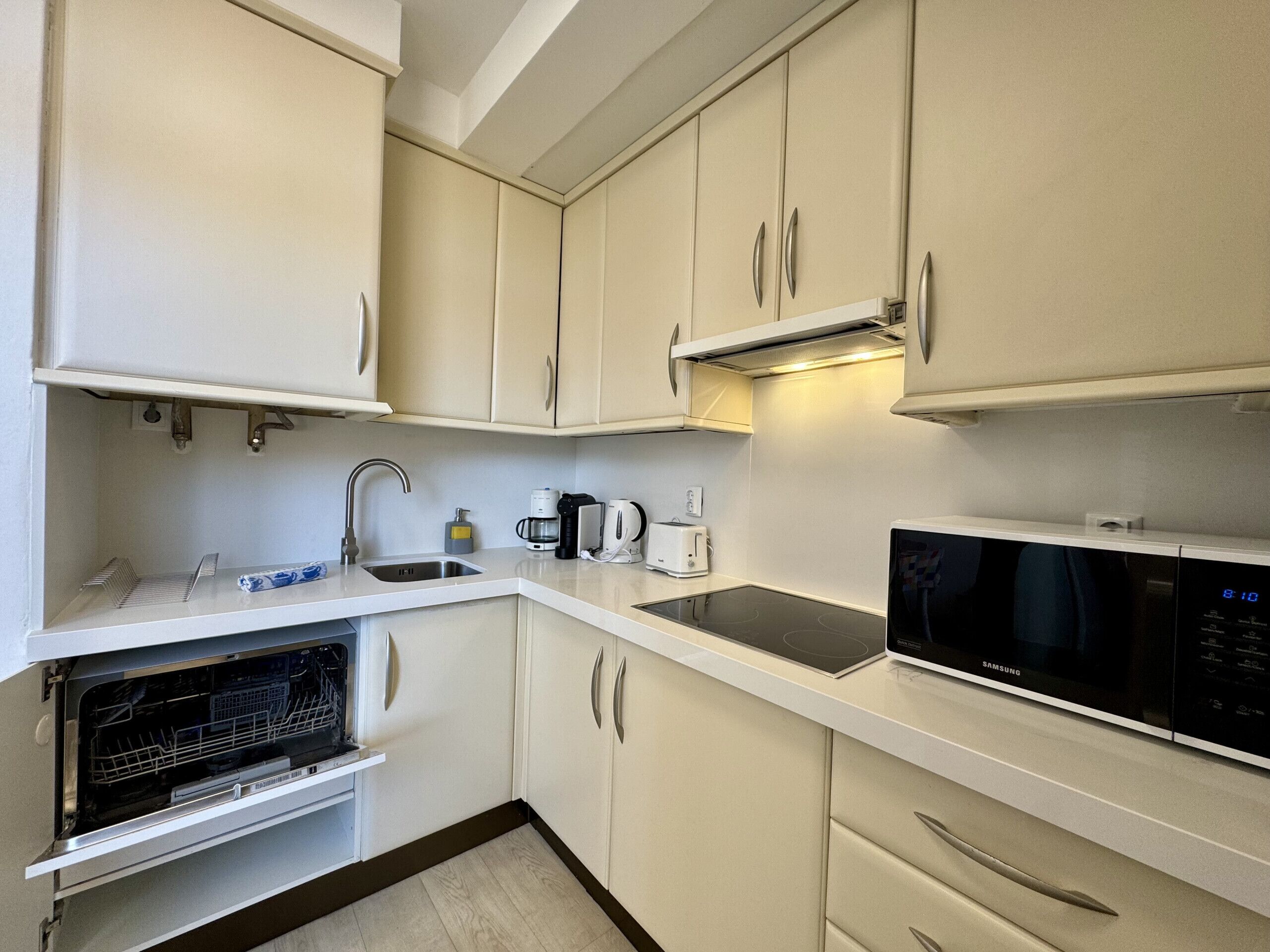 Um micro-ondas, uma cafeteira/bule, utensílios de cozinha 