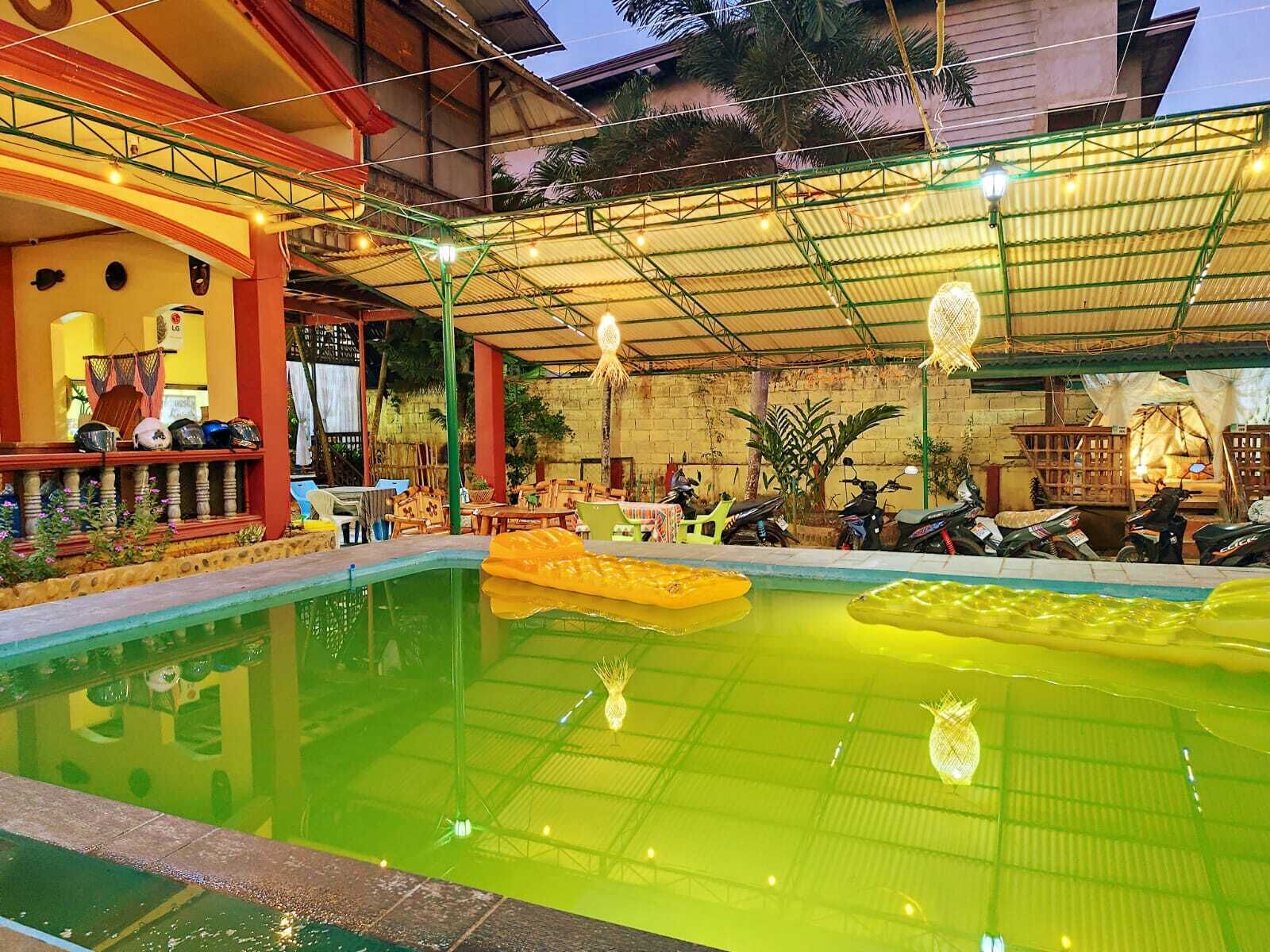 Uma piscina interior com área coberta, assentos e algumas motocicletas estacionadas perto.