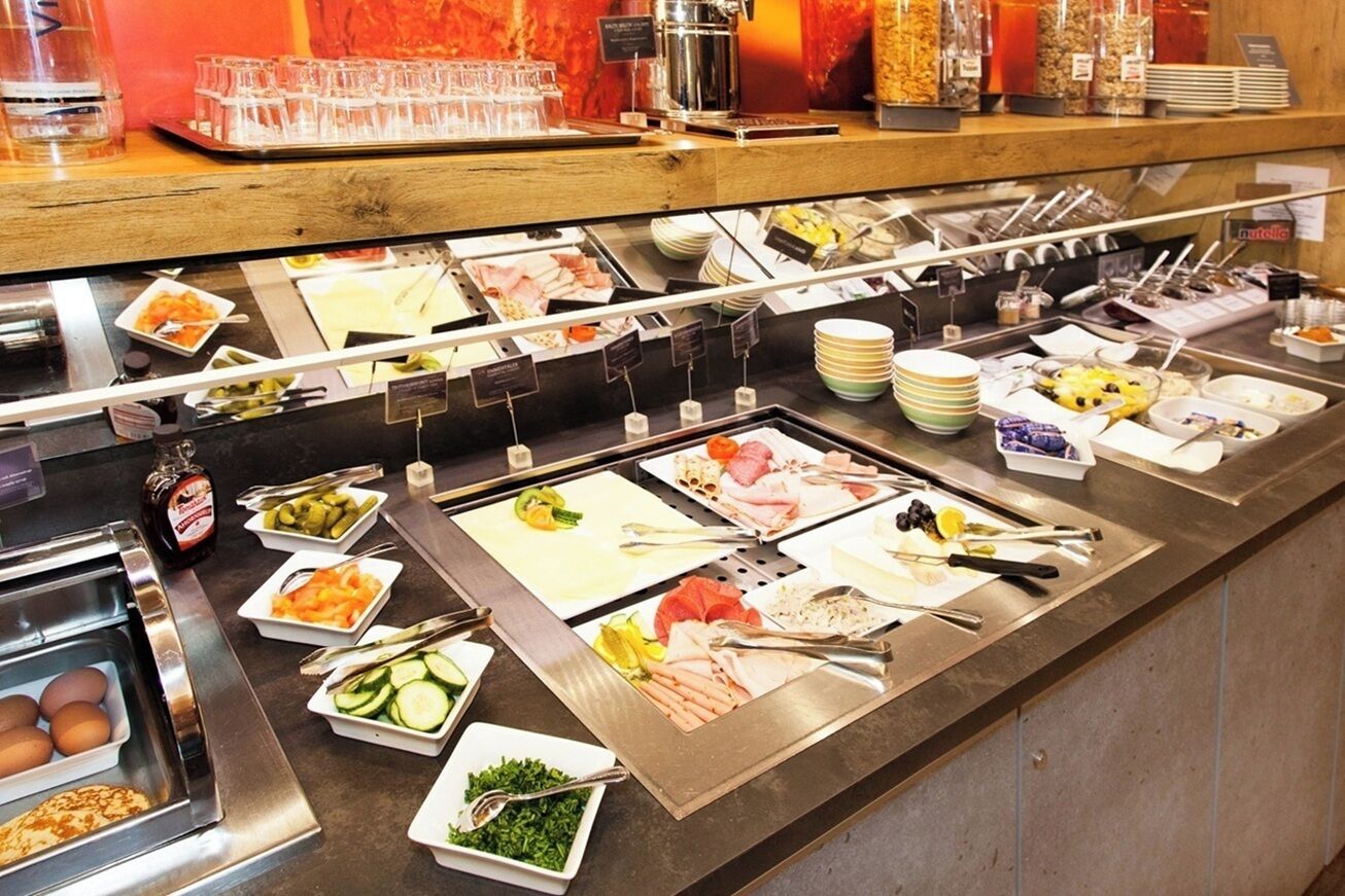 Um buffet com diversos alimentos e utensílios.