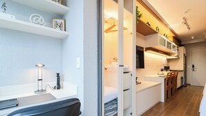 Uma cozinha moderna com armários brancos, bancada e área de jantar com cadeiras.