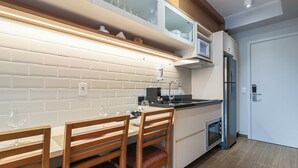Cozinha moderna com área de refeições, com forno embutido, micro-ondas e frigorífico.