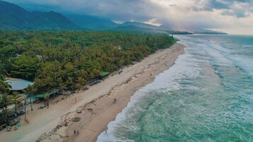 Na praia, espreguiçadeiras, toalhas de praia 