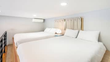 Quarto duplo com cama, mesa de cabeceira e ar condicionado fixado na parede.