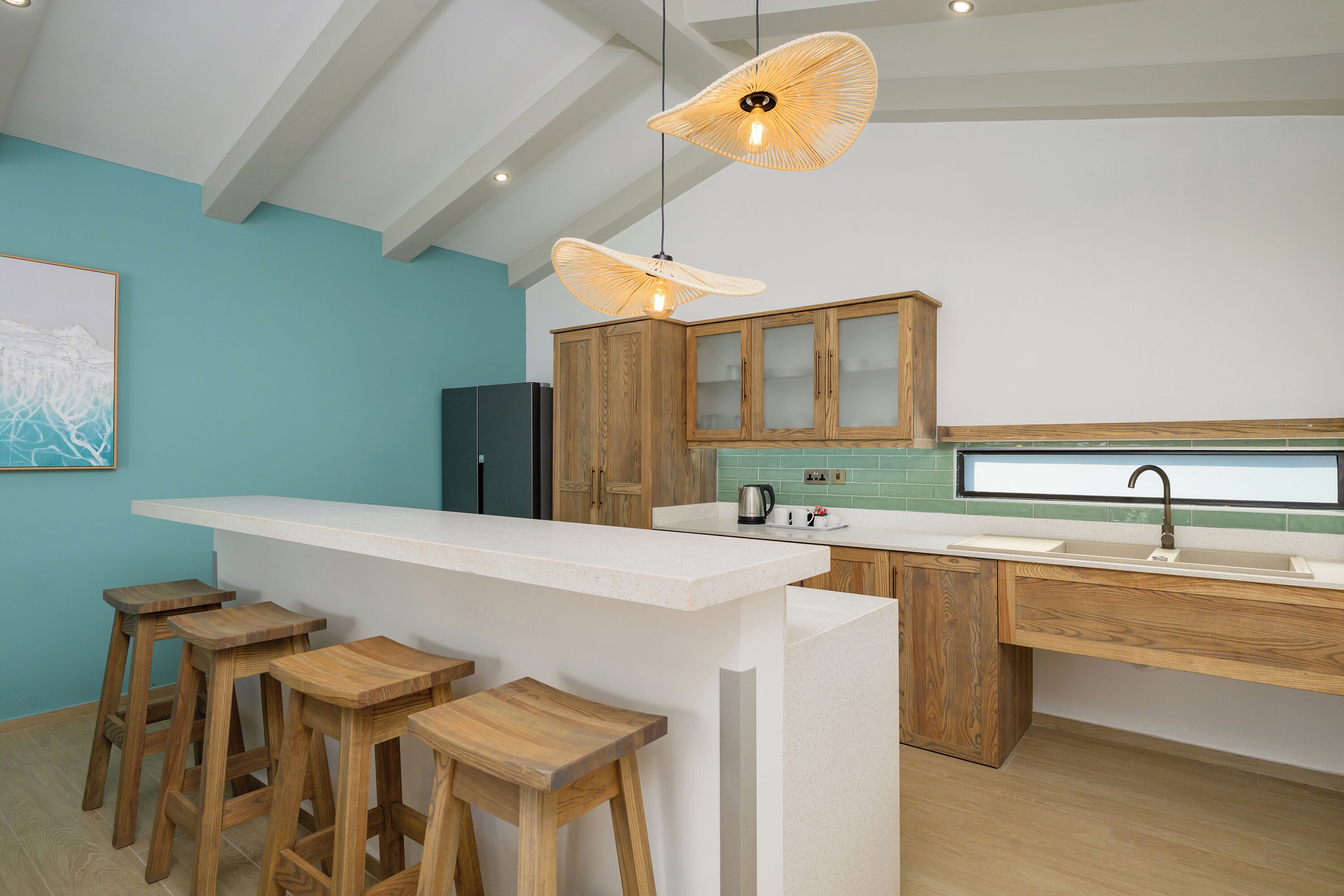 Uma cozinha moderna com área de bar, banquetas de madeira e um lustre.