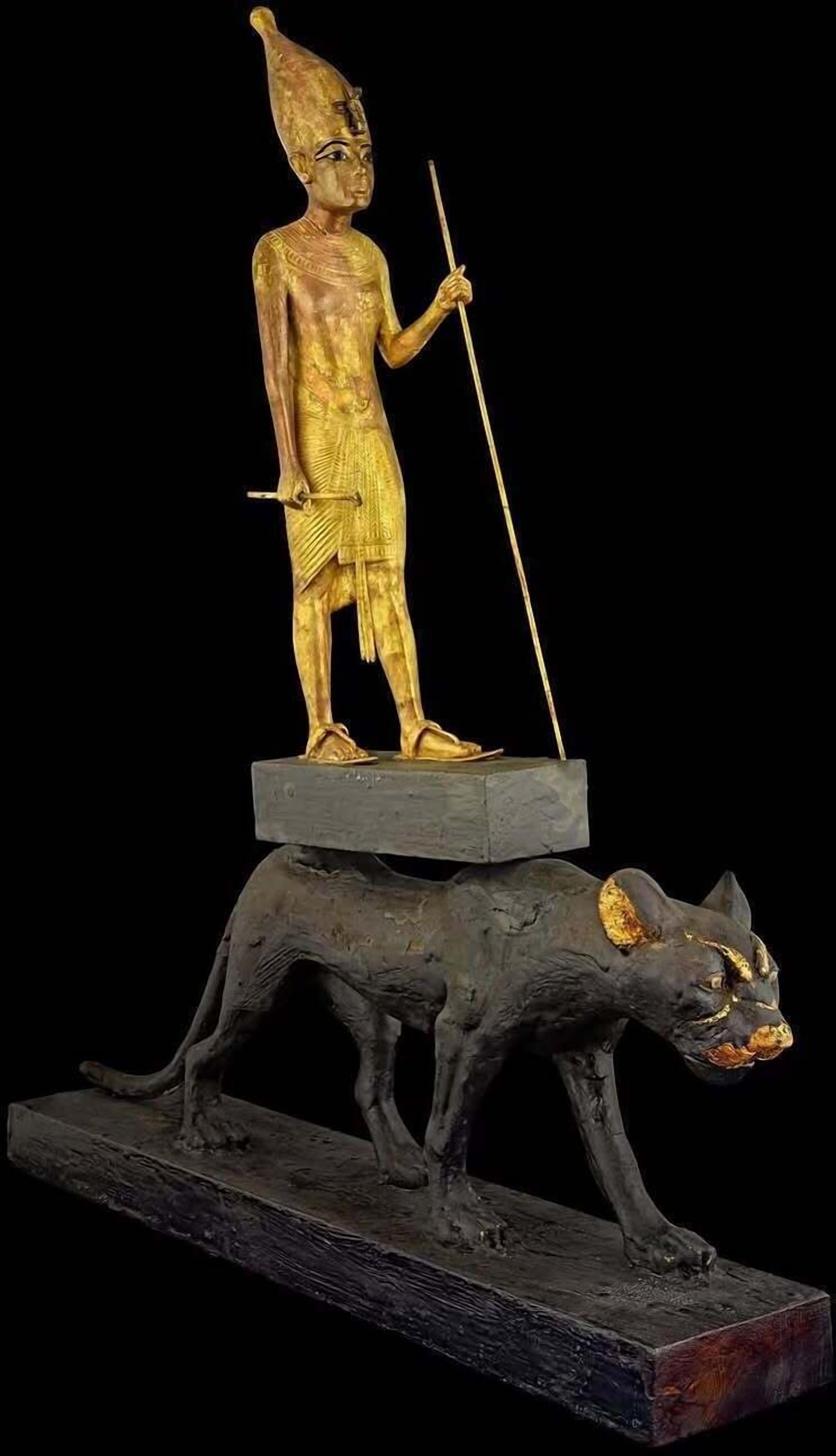 Estátua de um homem em pé sobre um pedestal, com um gato.