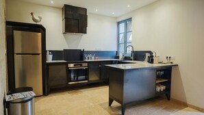 Cozinha moderna com ilha central, forno embutido e janela que proporciona iluminação natural.