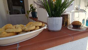 Uma bancada de cozinha com um prato de biscoitos, um vaso de planta e um pote de vidro com tampa.