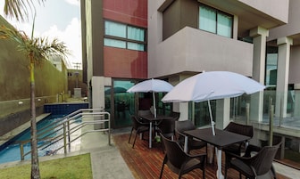 Uma área de piscina no terraço, com piscina, cadeiras e guarda-sóis.
