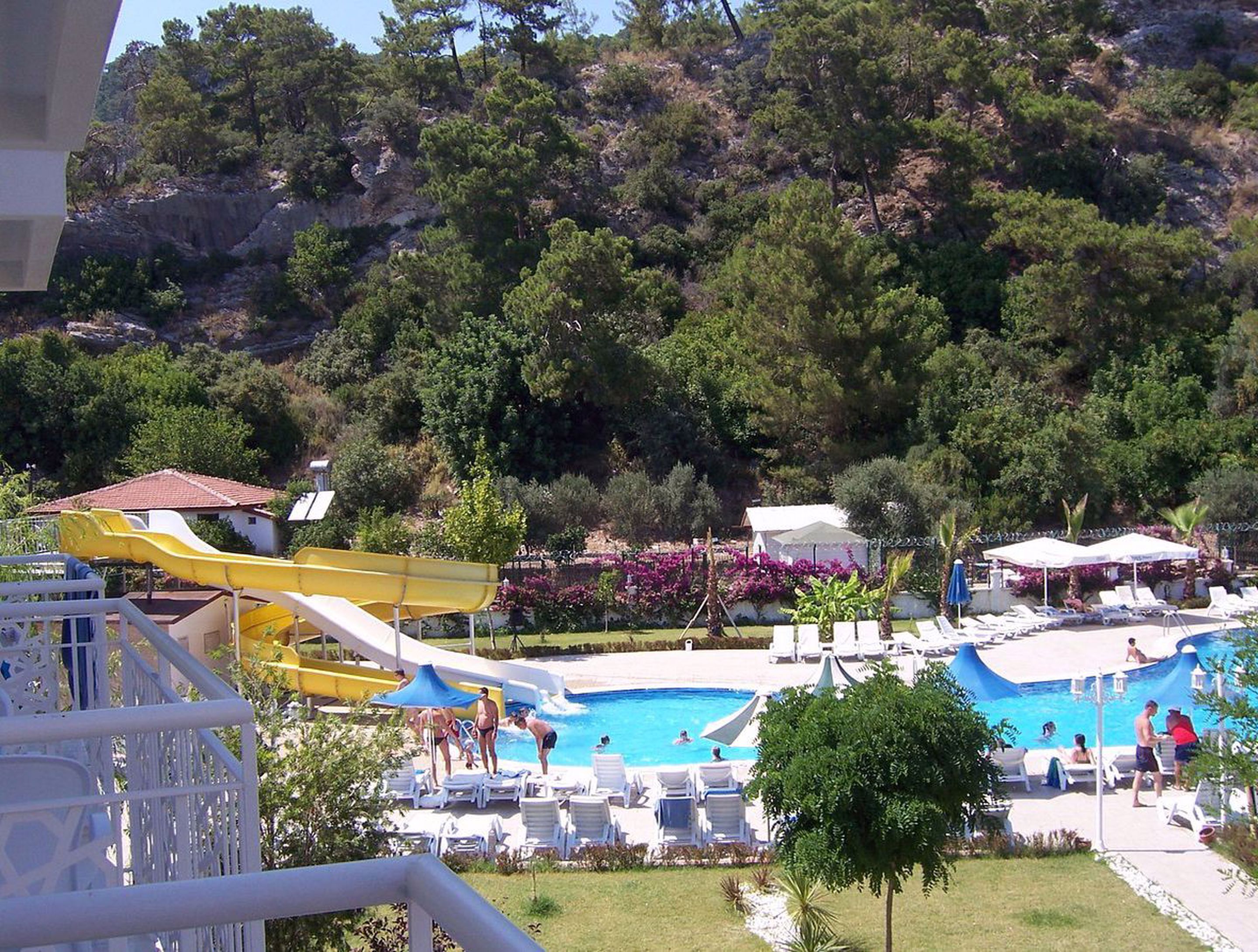 Uma área de piscina com vários toboáguas e cadeiras de descanso.