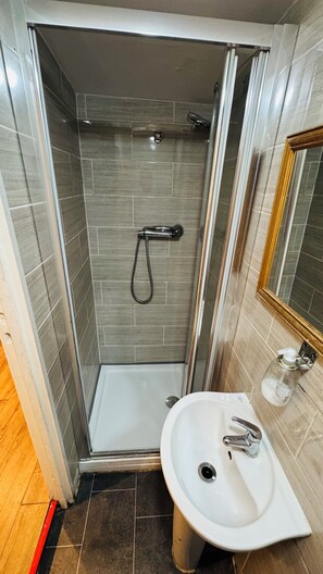 Quarto solteiro | Banheiro | Chuveiro, toalhas de banho, shampoo, papel higiênico