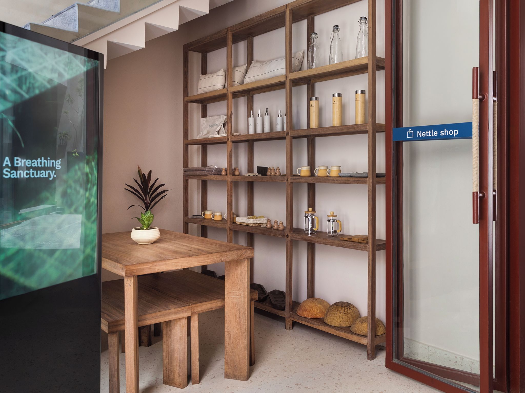 Um quarto com uma mesa de madeira, prateleiras com diversos objetos e uma placa indicando uma loja Nettle.