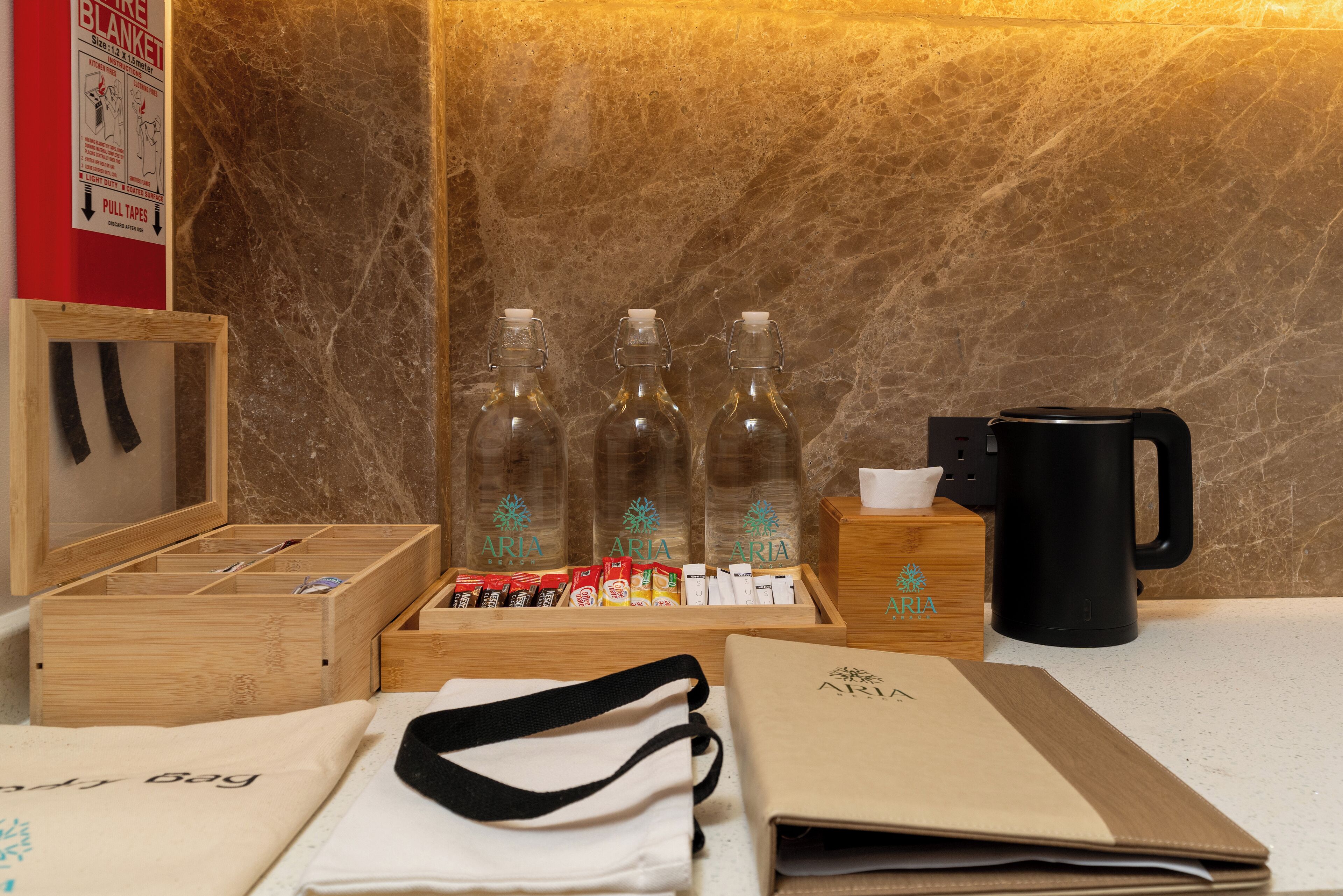 Caixa de madeira com caixa de lenços e caneca preta em uma bancada.