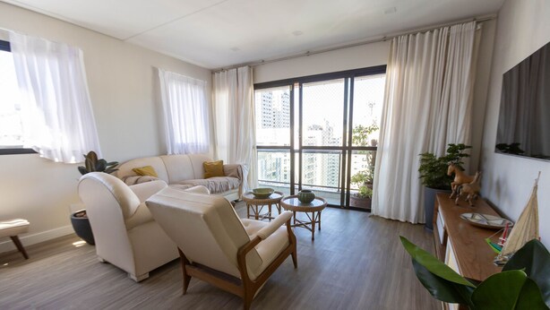 Uma sala de estar moderna com sofá, poltronas, mesa de centro e área de jantar com mesa e cadeiras.